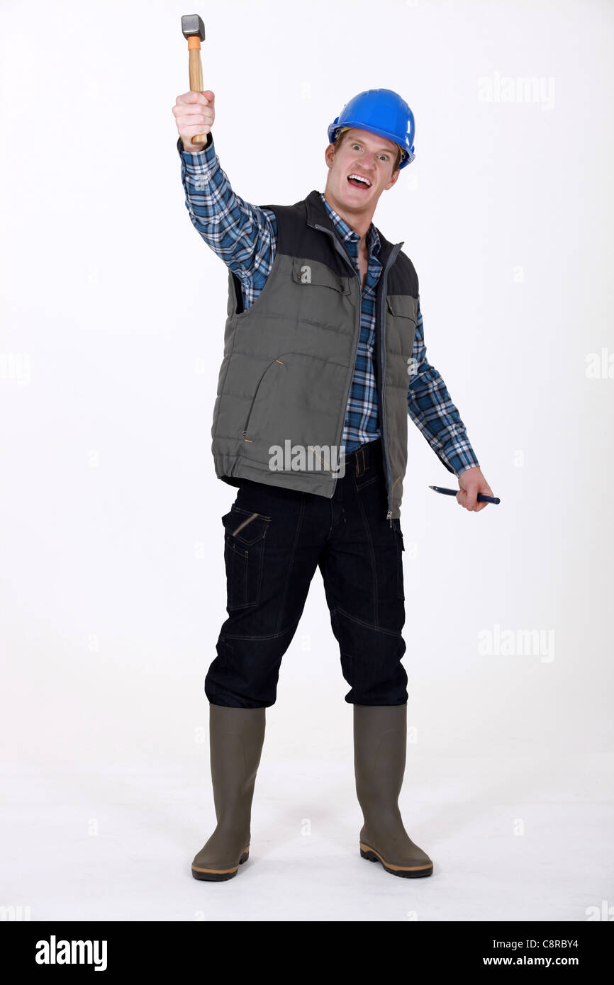 A mad construction worker with a hammer Stock Photo - Alamy