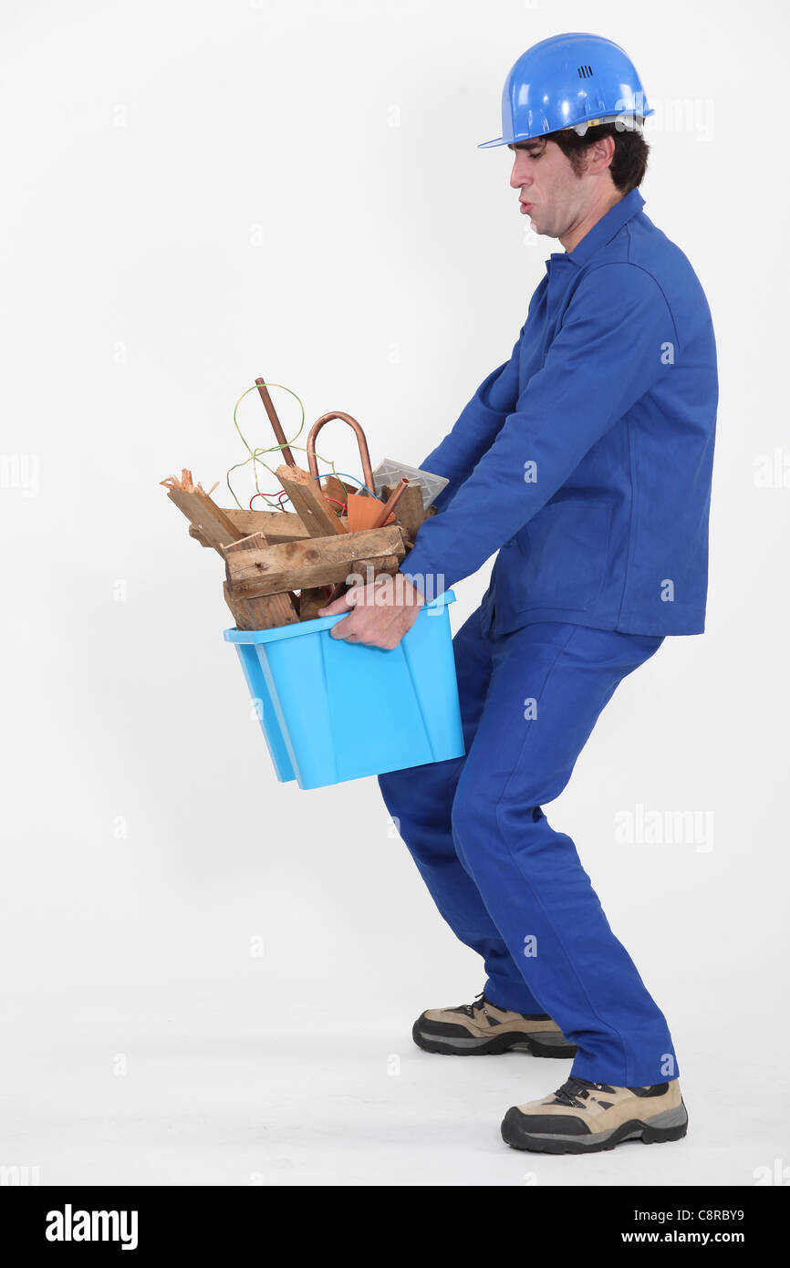 Builder carrying box of waste Stock Photo - Alamy