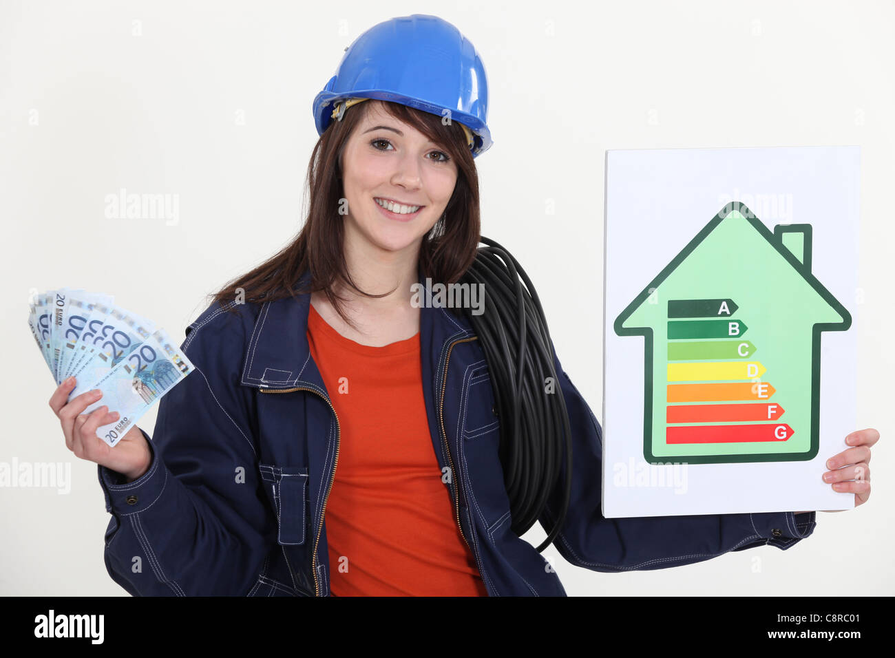Electrician holding cash and an energy rating sign Stock Photo - Alamy