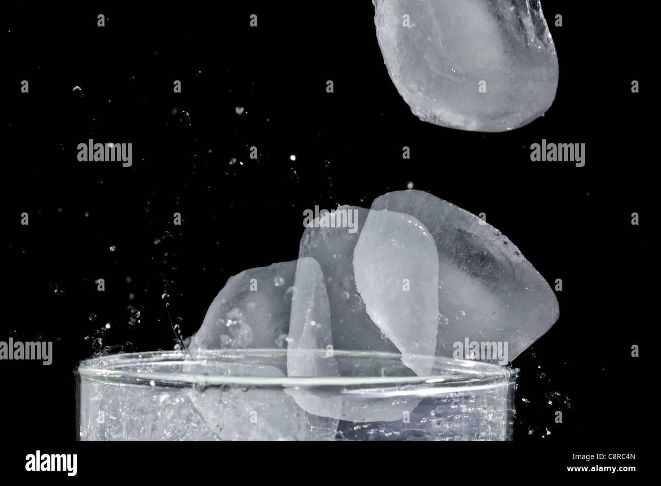 The motion of ice splashing into a glass of water frozen in time Stock ...