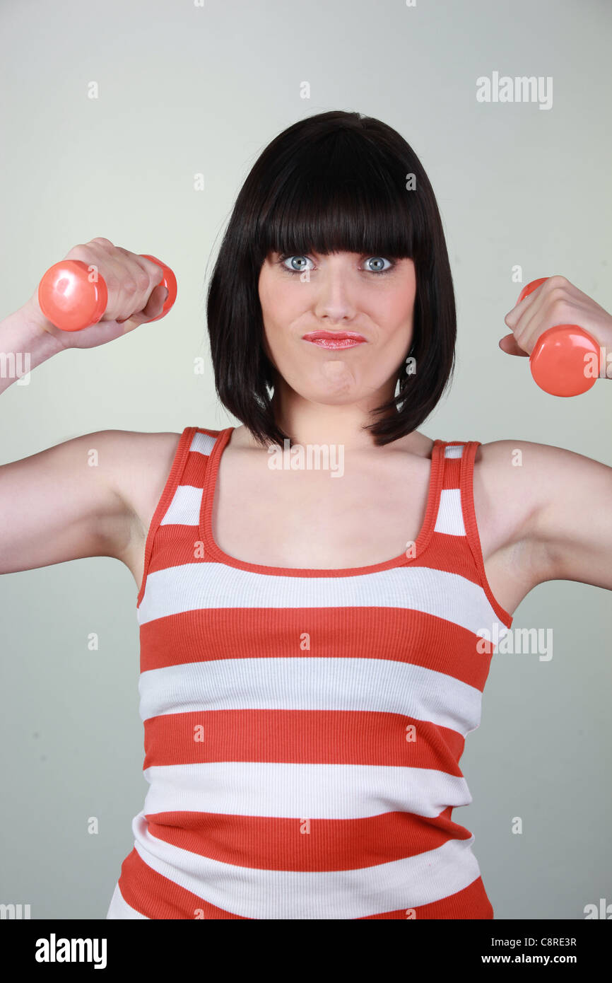 Young woman using dumbbells Stock Photo - Alamy