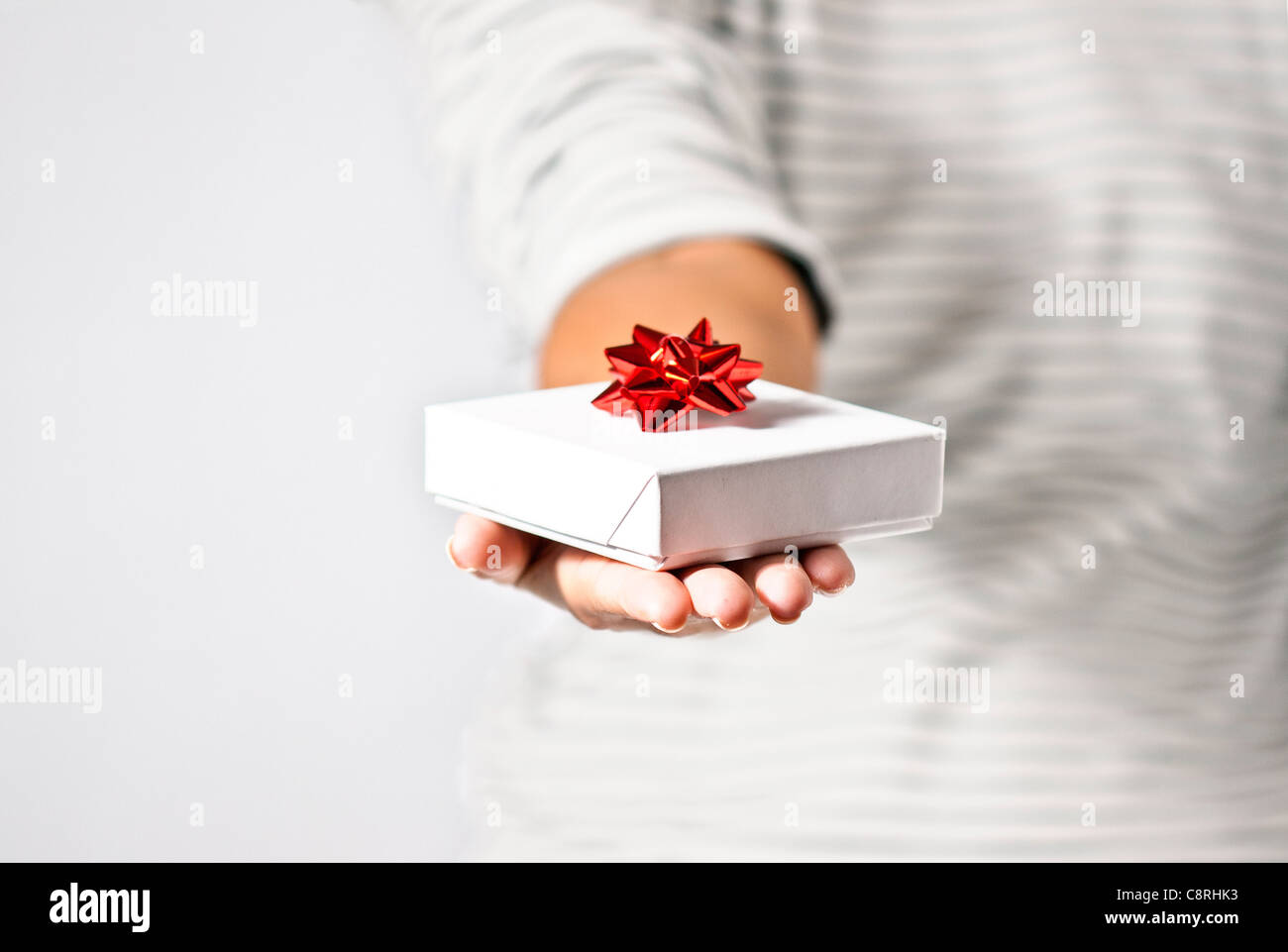 Close-up photograph of a young woman handing a gift Stock Photo - Alamy