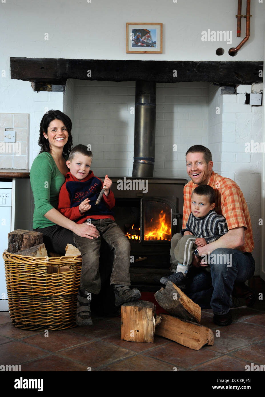 A family using a solid fuel wood burning stove to heat their house UK ...