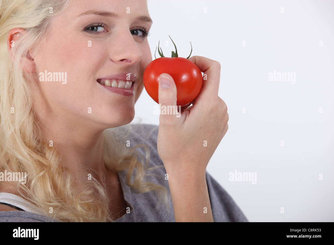 Young woman eating a tomato Stock Photo - Alamy