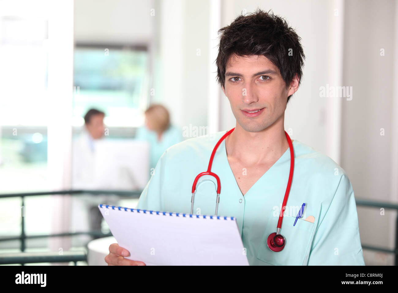 Young hospital doctor checking notes Stock Photo - Alamy