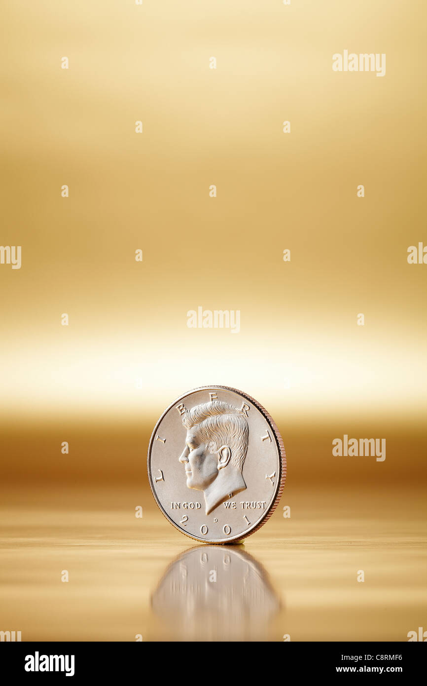 Single metal coin against golden background Stock Photo - Alamy
