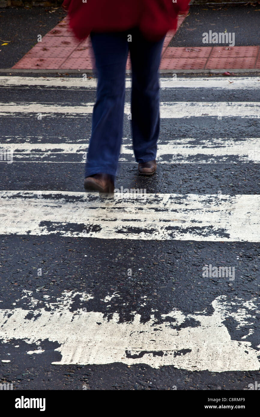 Unidentified Person Walking Across Zebra Crossing Stock Photo - Alamy
