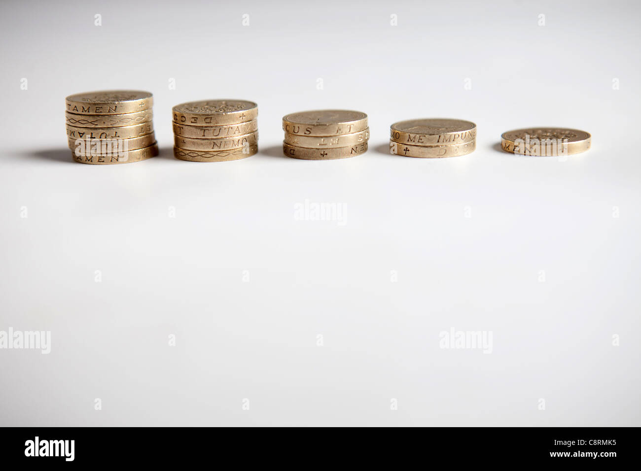 Stacks of pound coins lined up on a white background Stock Photo - Alamy