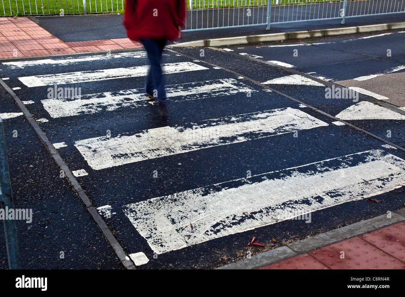 Unidentified Person Walking Across a Zebra Crossing Stock Photo - Alamy