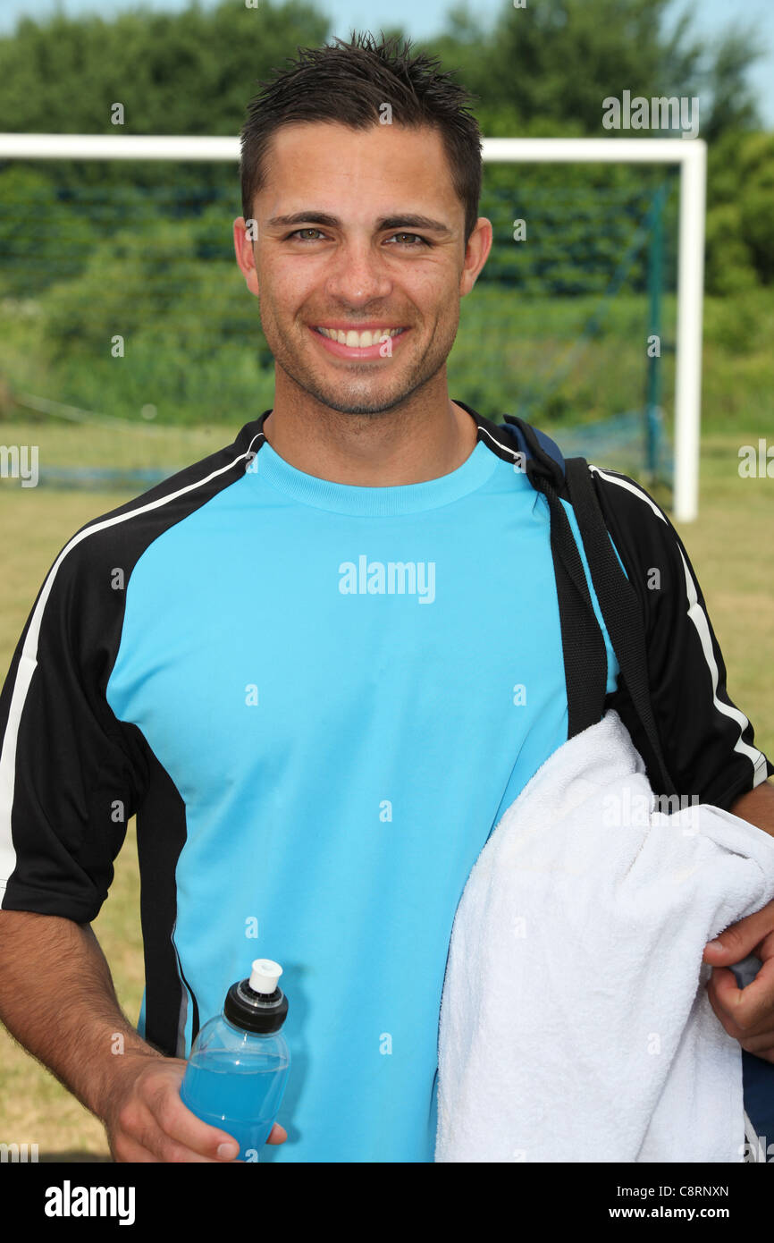 Man stood on soccer pitch holding energy drink and towel Stock Photo ...