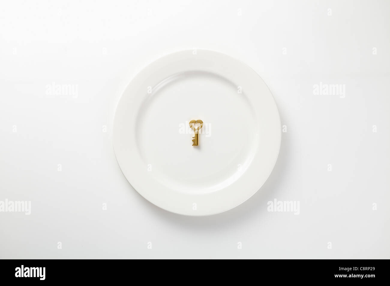 Gold key on plate Stock Photo - Alamy