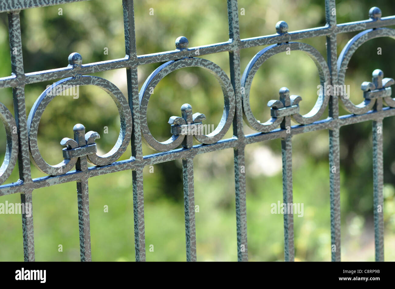 a scrolling iron fence outdoors against a green background Stock Photo ...