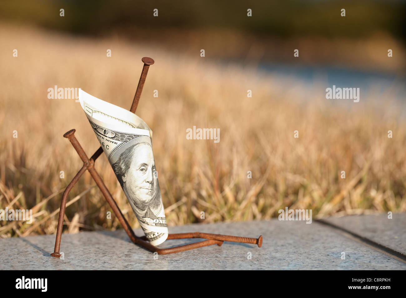 Folded American currency note along with nails, outdoors Stock Photo ...
