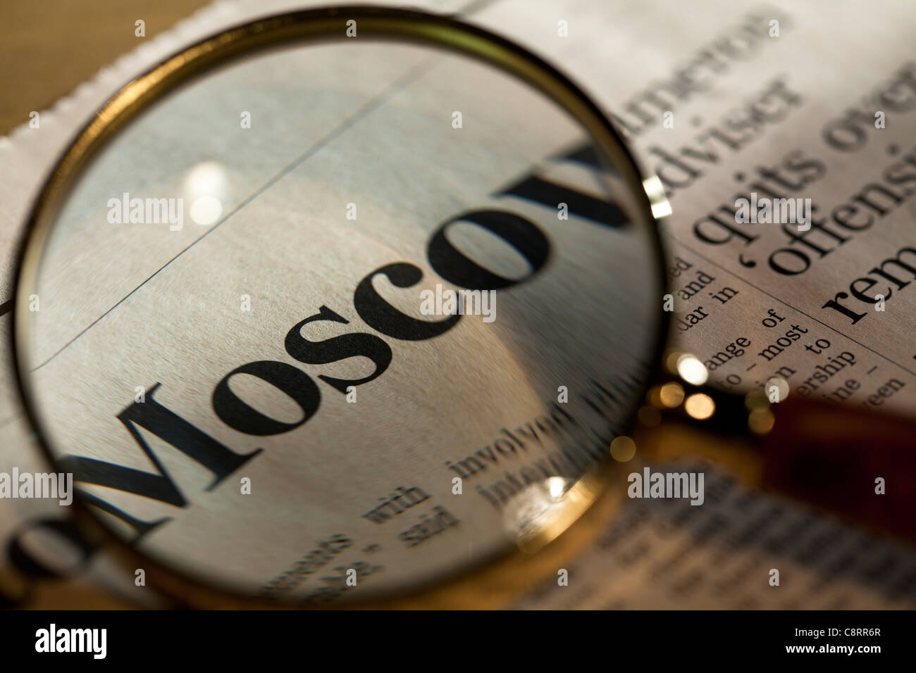 Magnifying glass enlarging corporate business news from newspaper Stock ...