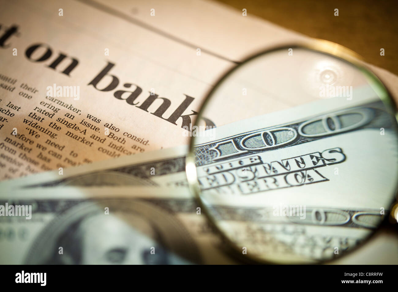 Looking at paper currency on newspaper through magnifying glass Stock ...