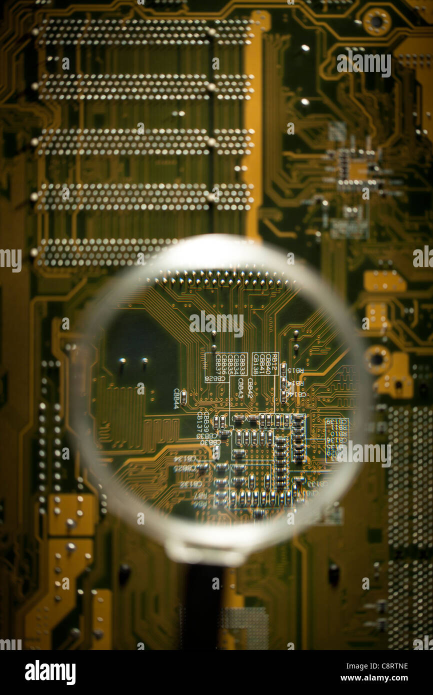 Looking at circuit board through magnifying glass Stock Photo - Alamy