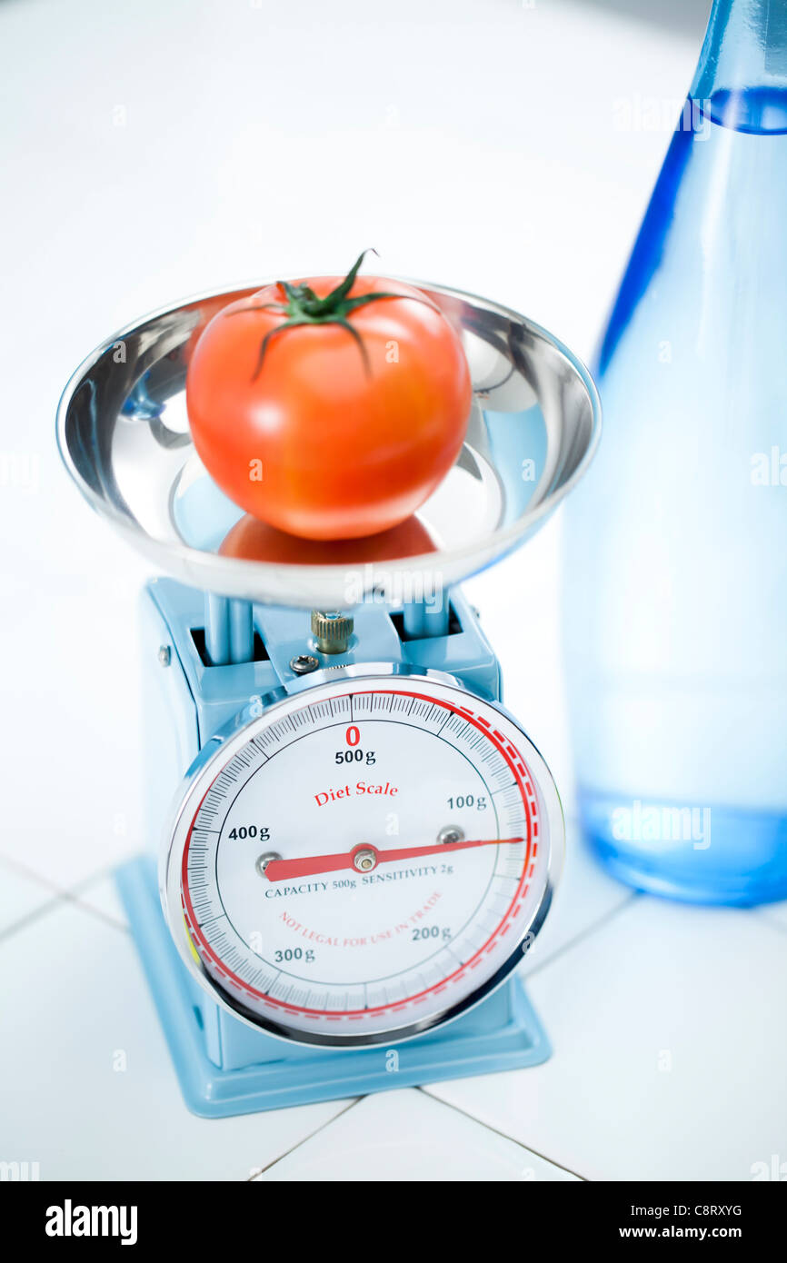Close-up of tomato on weighing scale with water bottle Stock Photo - Alamy