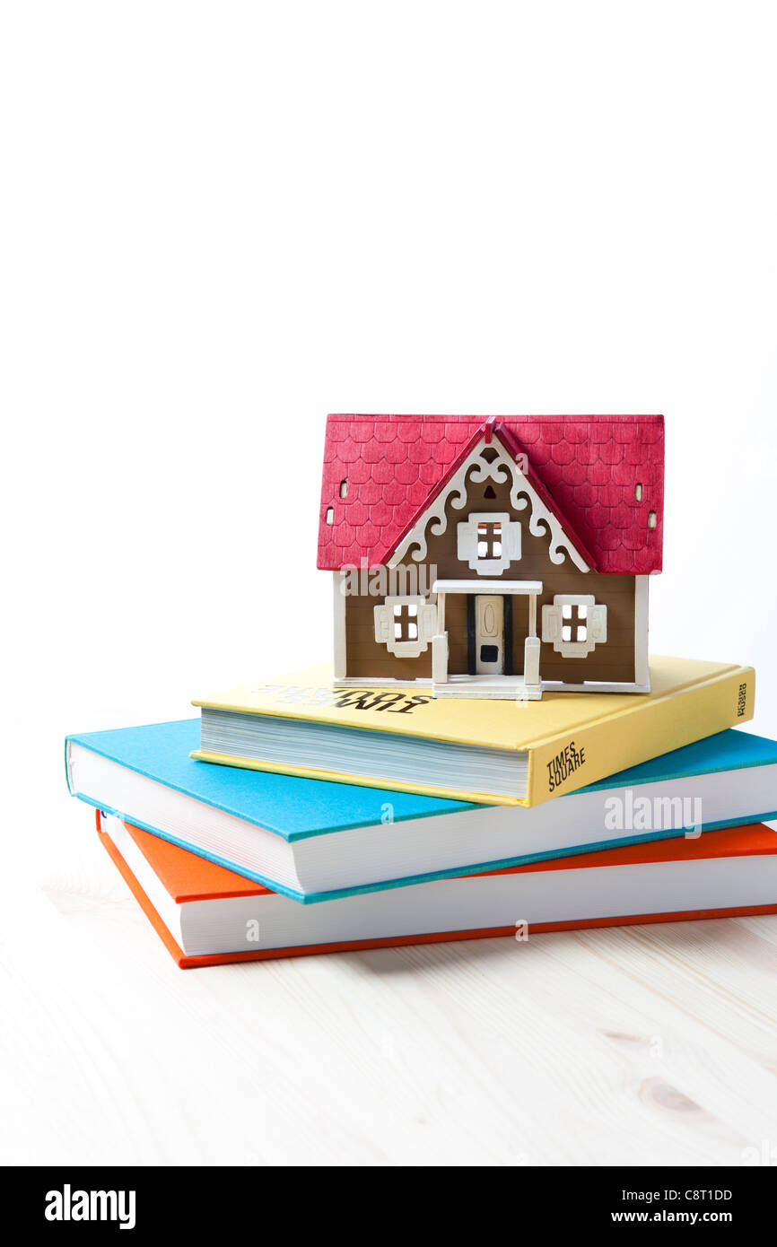 Model house placed on stack of books against white background Stock ...