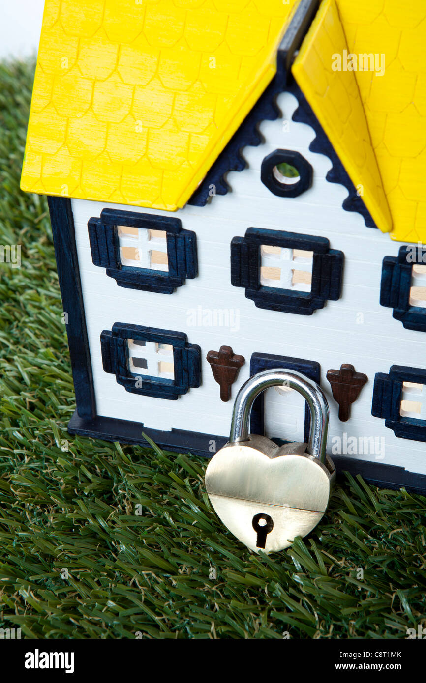 Close up of model of house with a padlock placed on grass Stock Photo ...
