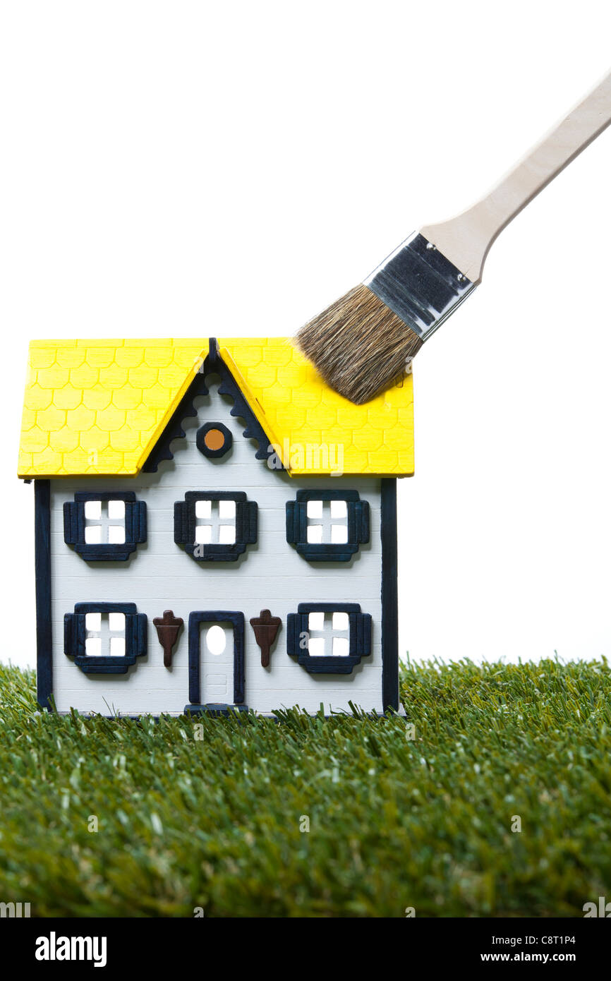 Architectural model of house with paintbrush against white background ...