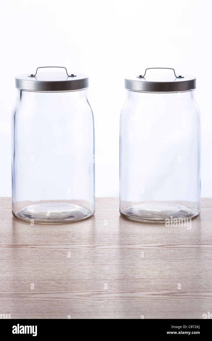 Two empty glass jar on table against white background Stock Photo - Alamy