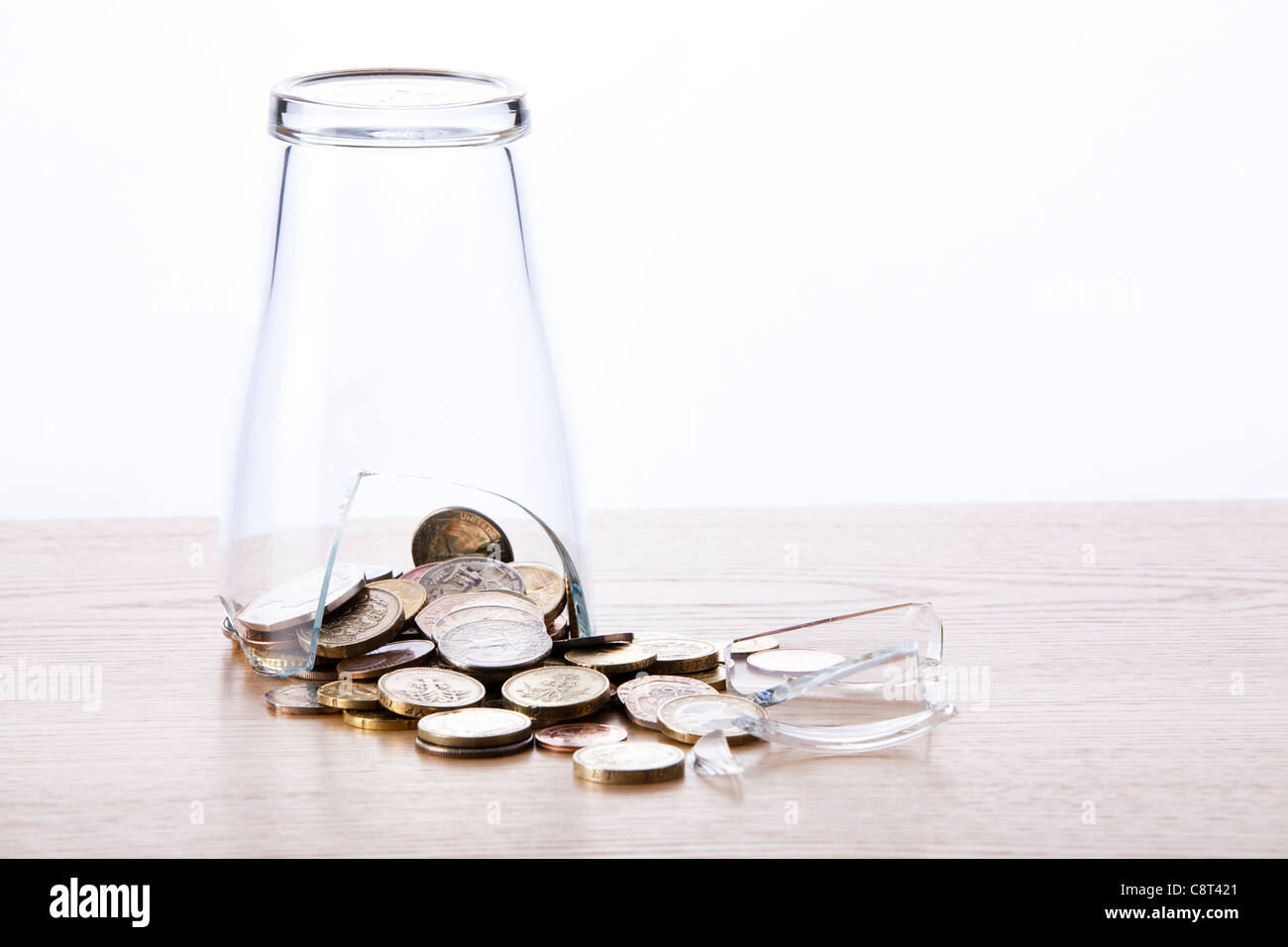 Glass upside down with money inside it Stock Photo - Alamy