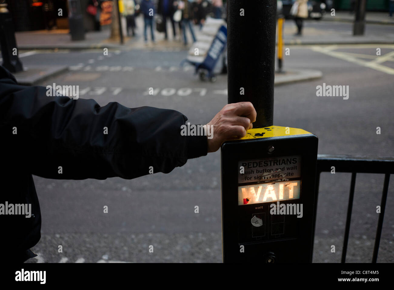 An arm and hand rests on a city crossing signal box in the capital's ...