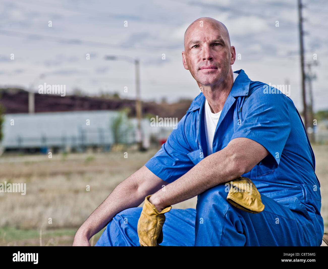 Serious mechanic in coveralls relaxing Stock Photo - Alamy