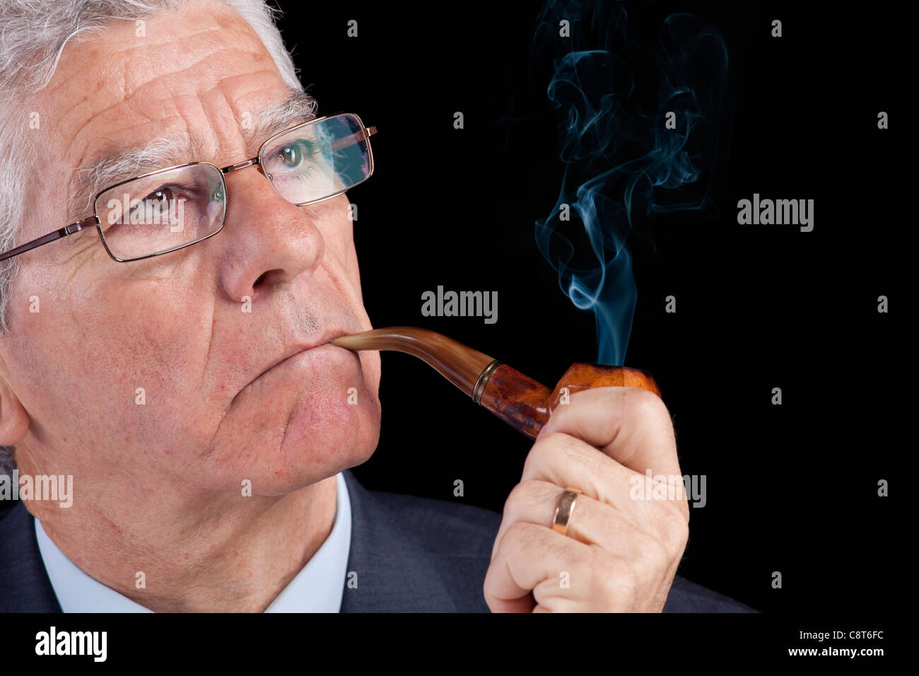 Senior businessman thinking while smoking his pipe (isolated on black ...