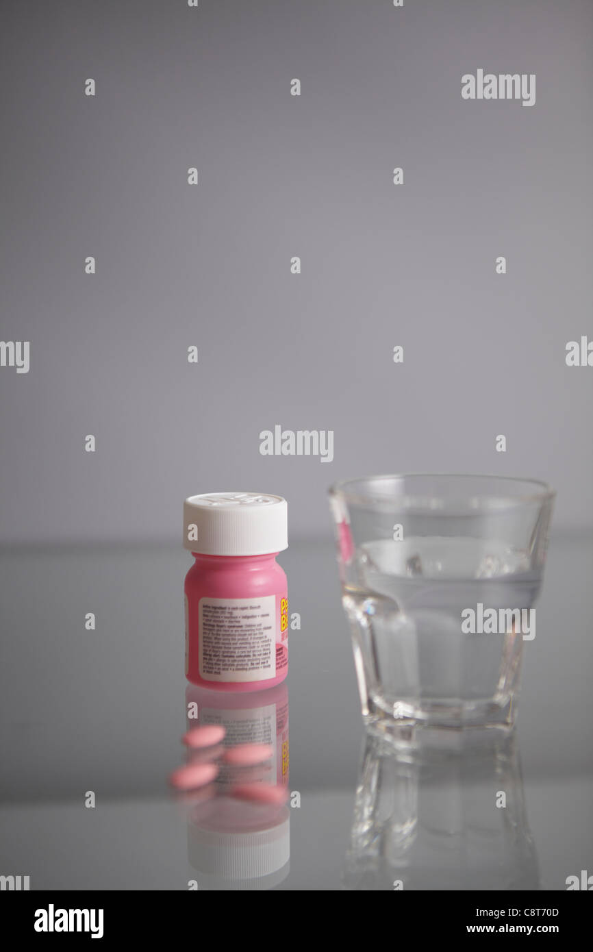 Glass of water with pink pill bottle and capsules Stock Photo - Alamy
