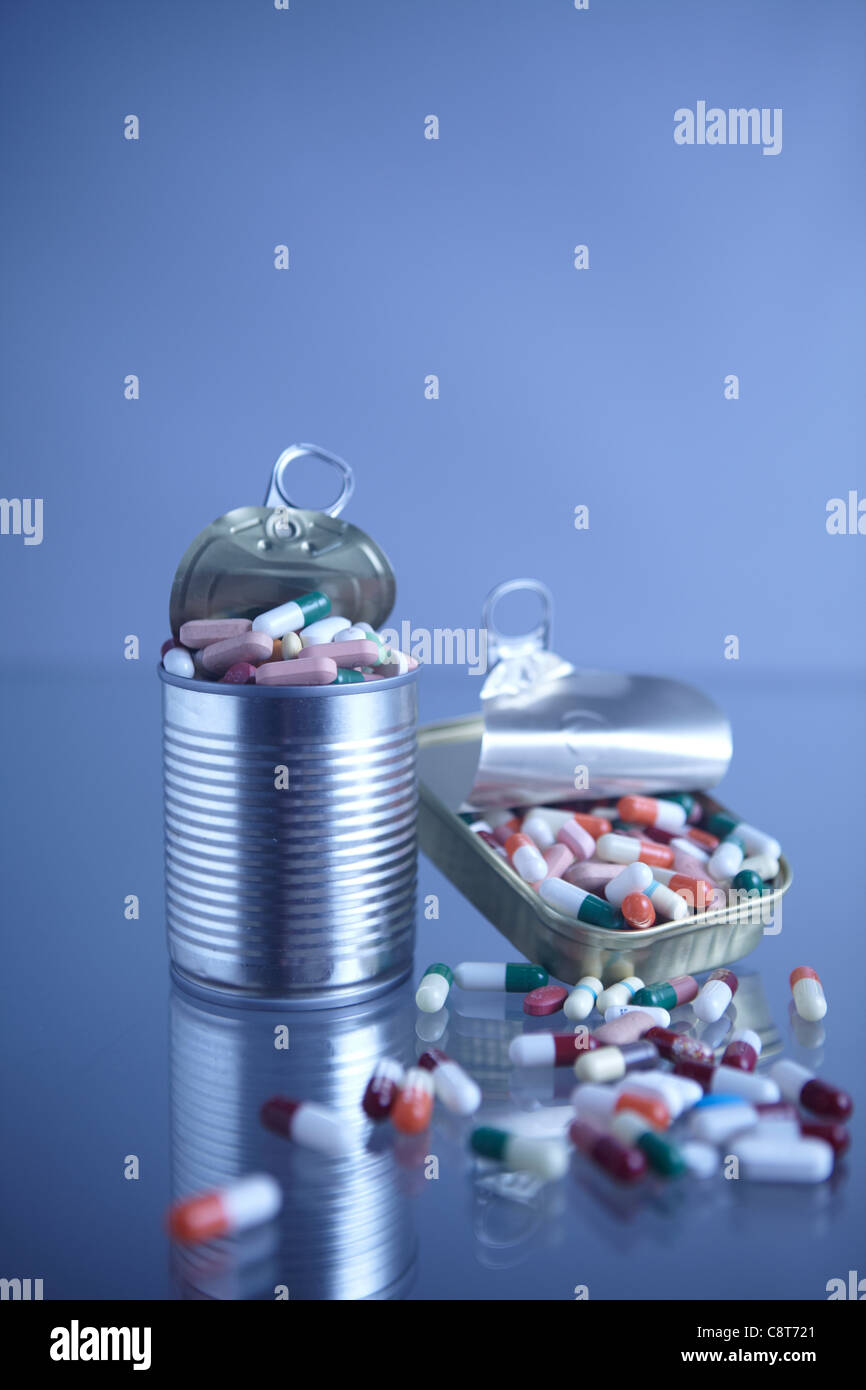 Capsules spilling off from capsule can and box Stock Photo - Alamy