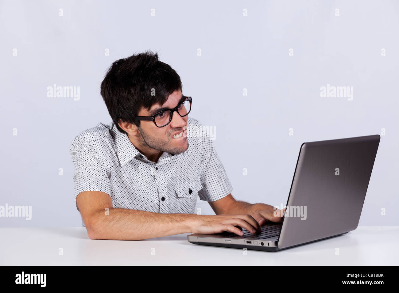 Nerd teenager working with his laptop with a funny face Stock Photo - Alamy