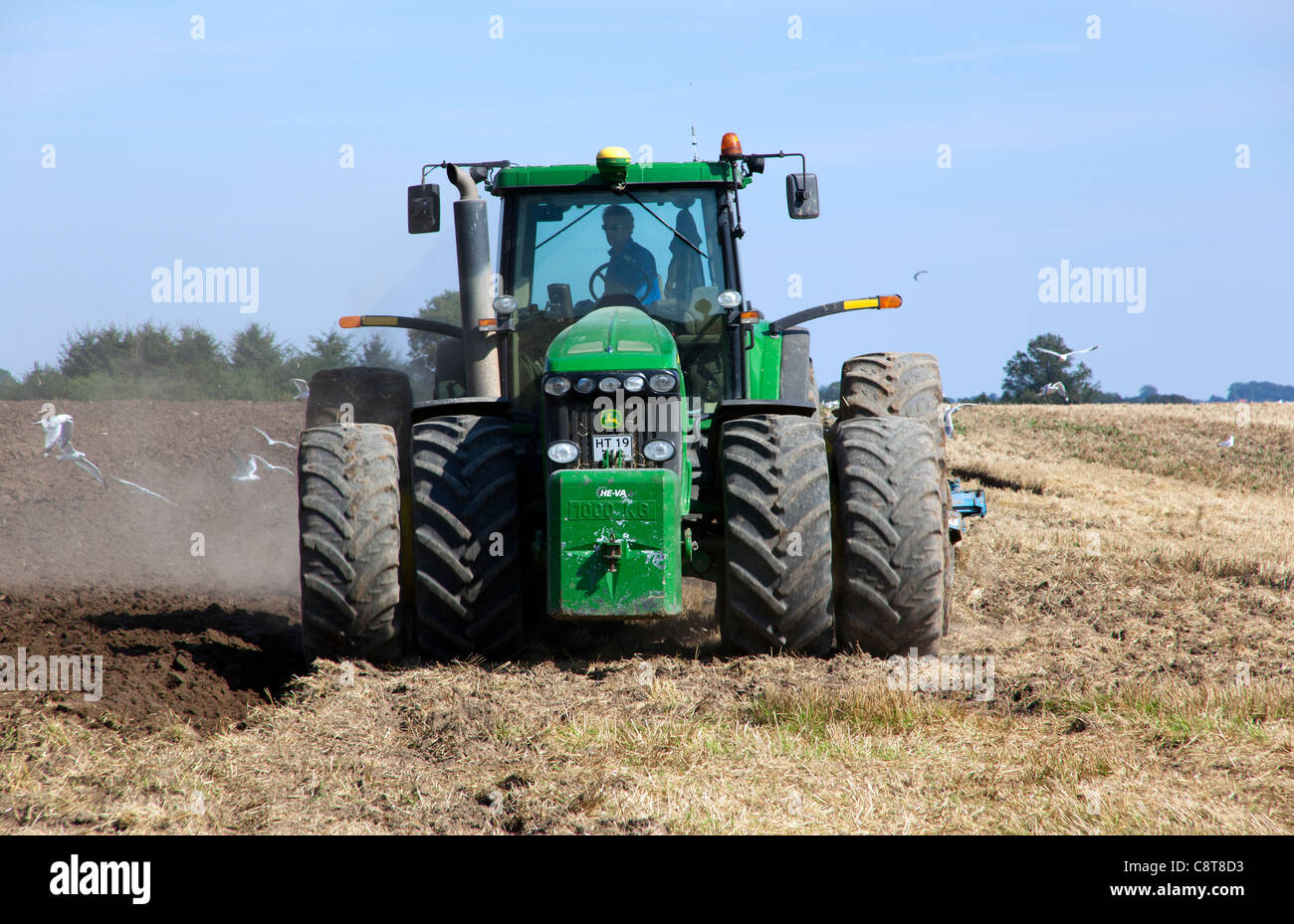 Big tractor pull a plough on a late summer stubble field. Mid Zealand ...