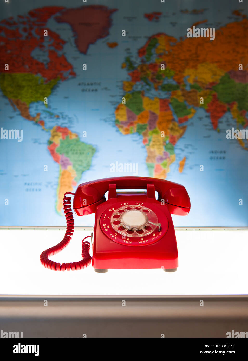 Studio shot of red phone in front of world map Stock Photo - Alamy