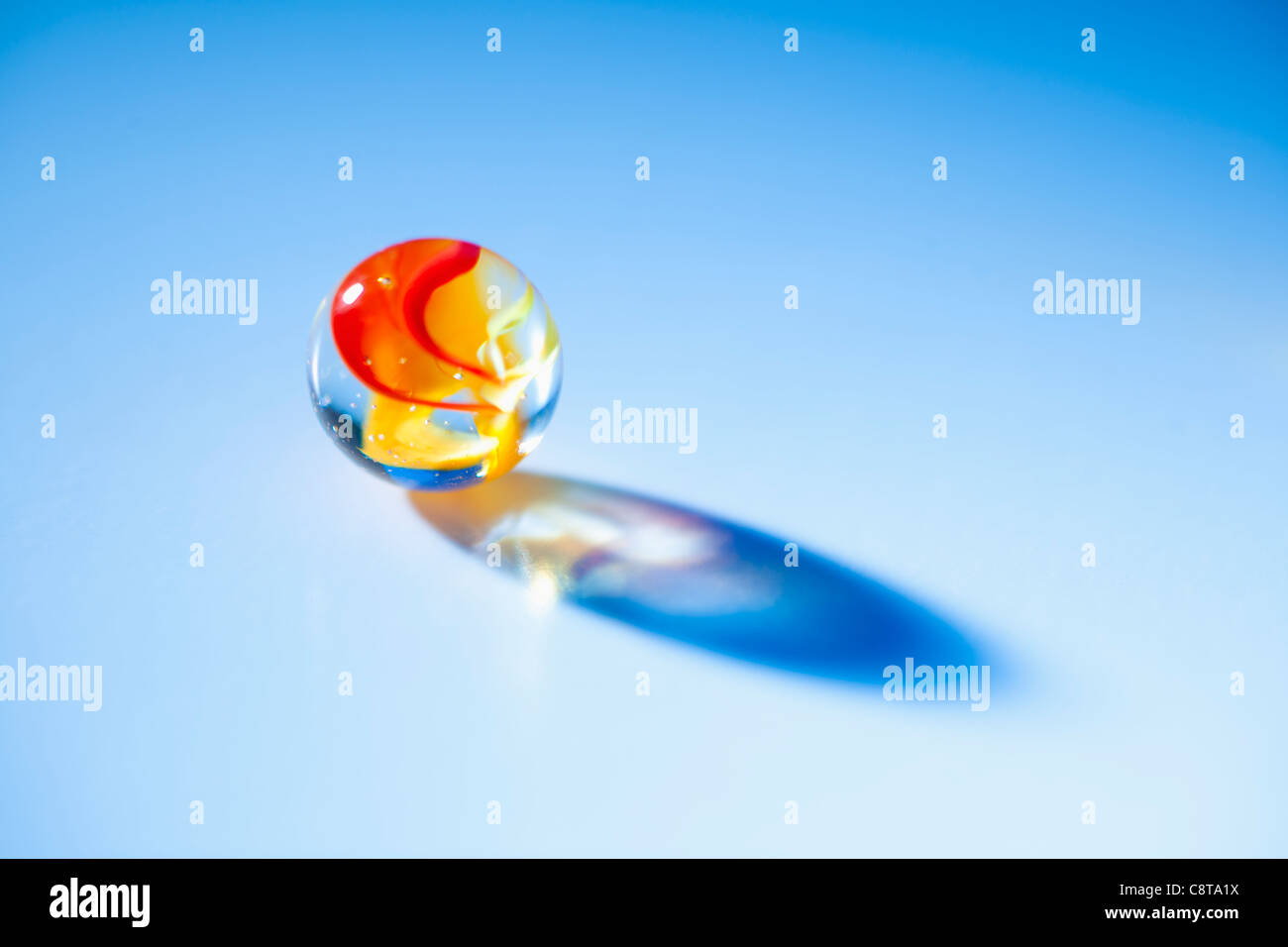 Studio shot of marble ball on blue background Stock Photo - Alamy