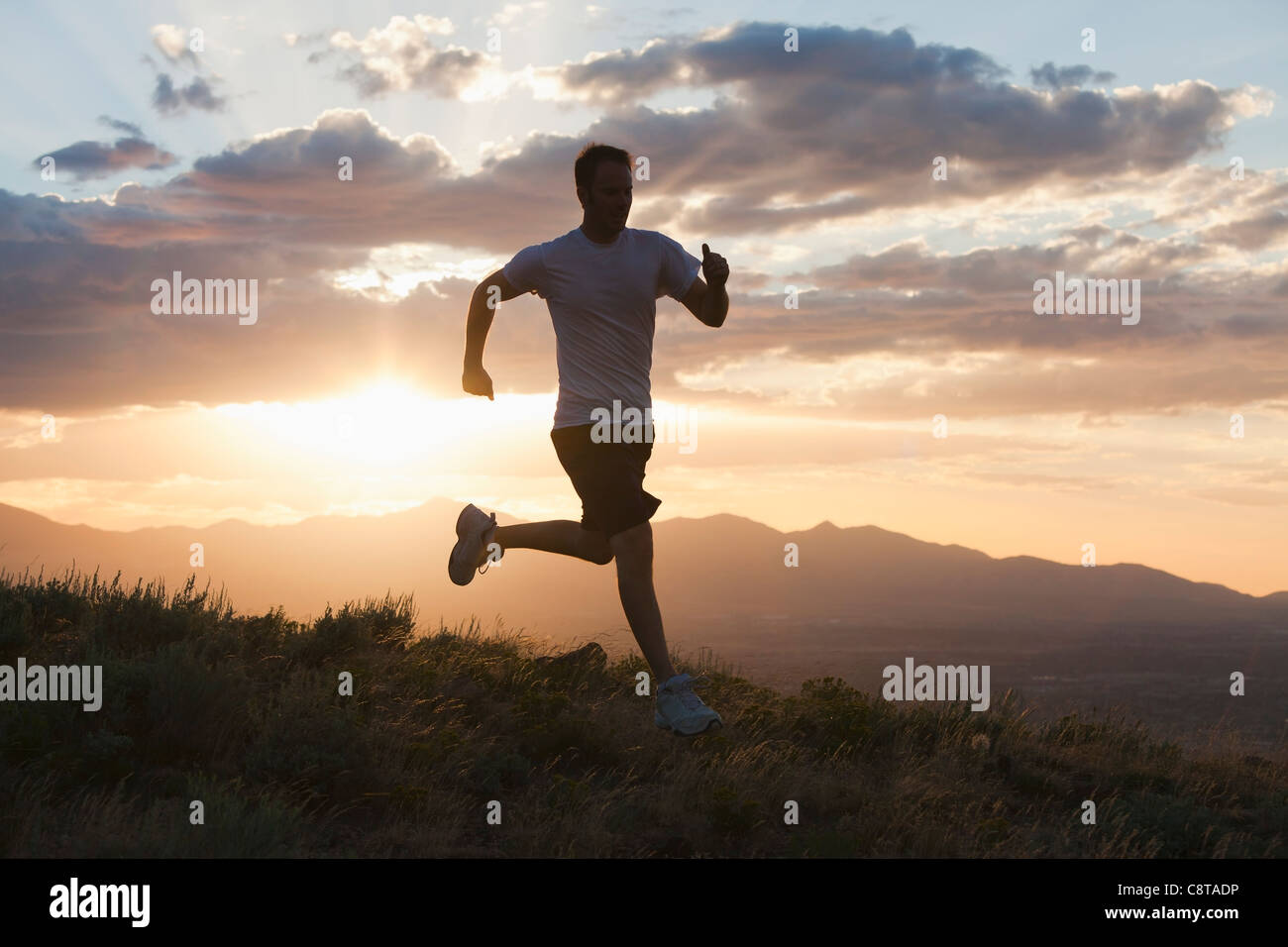 Caucasian man running on remote hill Stock Photo - Alamy