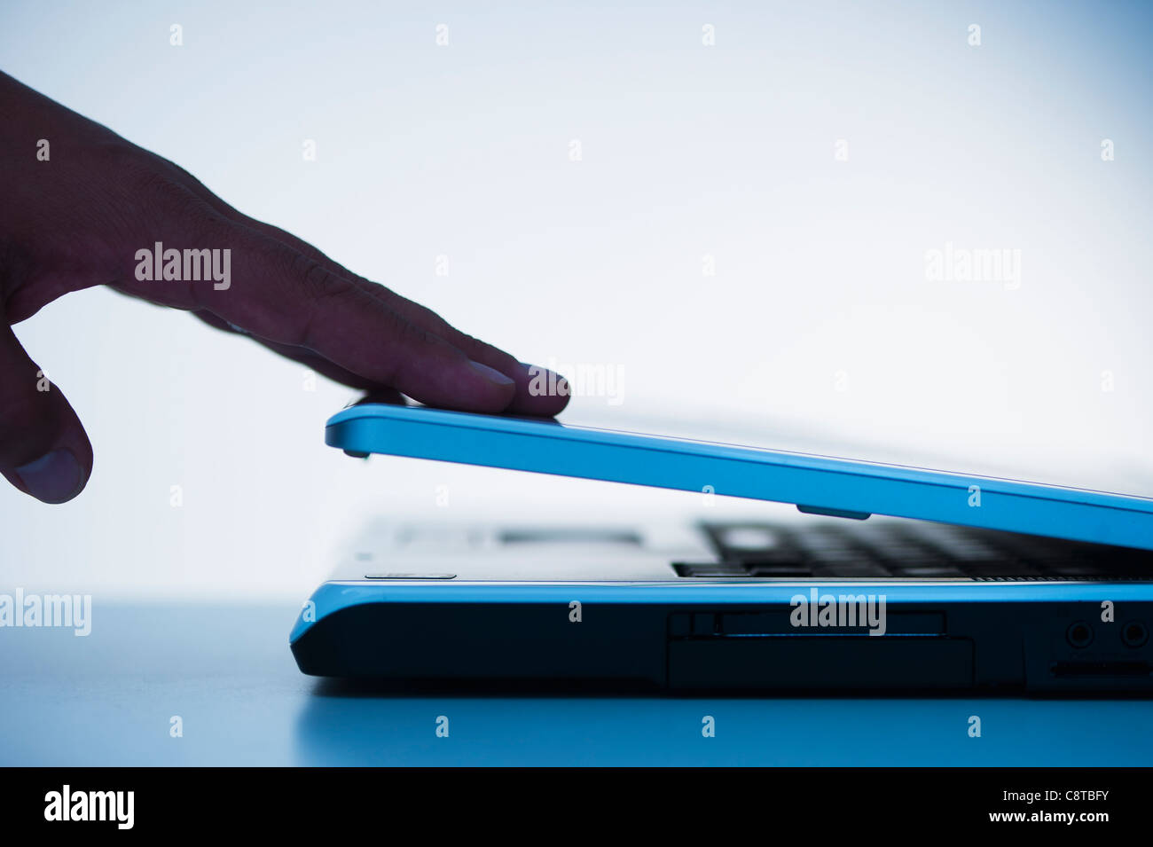 Studio shot of hand closing laptop Stock Photo - Alamy