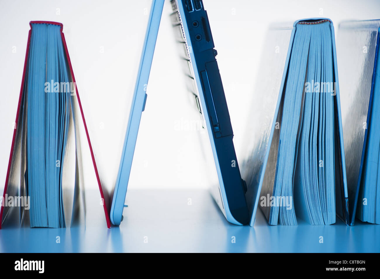 Studio shot of books and laptop Stock Photo - Alamy