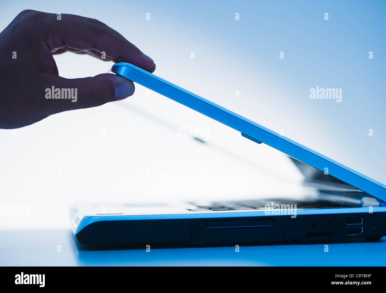 Studio shot of hand opening laptop Stock Photo - Alamy