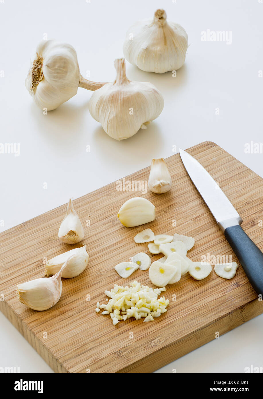 Studio shot of fresh garlic being chopped on cutting board Stock Photo ...