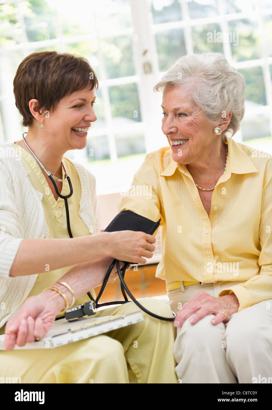 USA, New York State, Old Westbury, Nurse taking pulse of senior woman ...