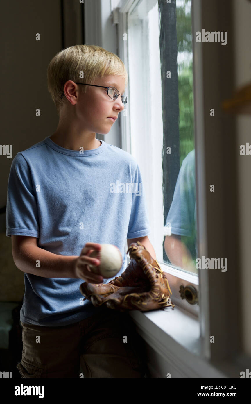USA, New York State, Old Westbury, Boy holding baseball glove looking ...