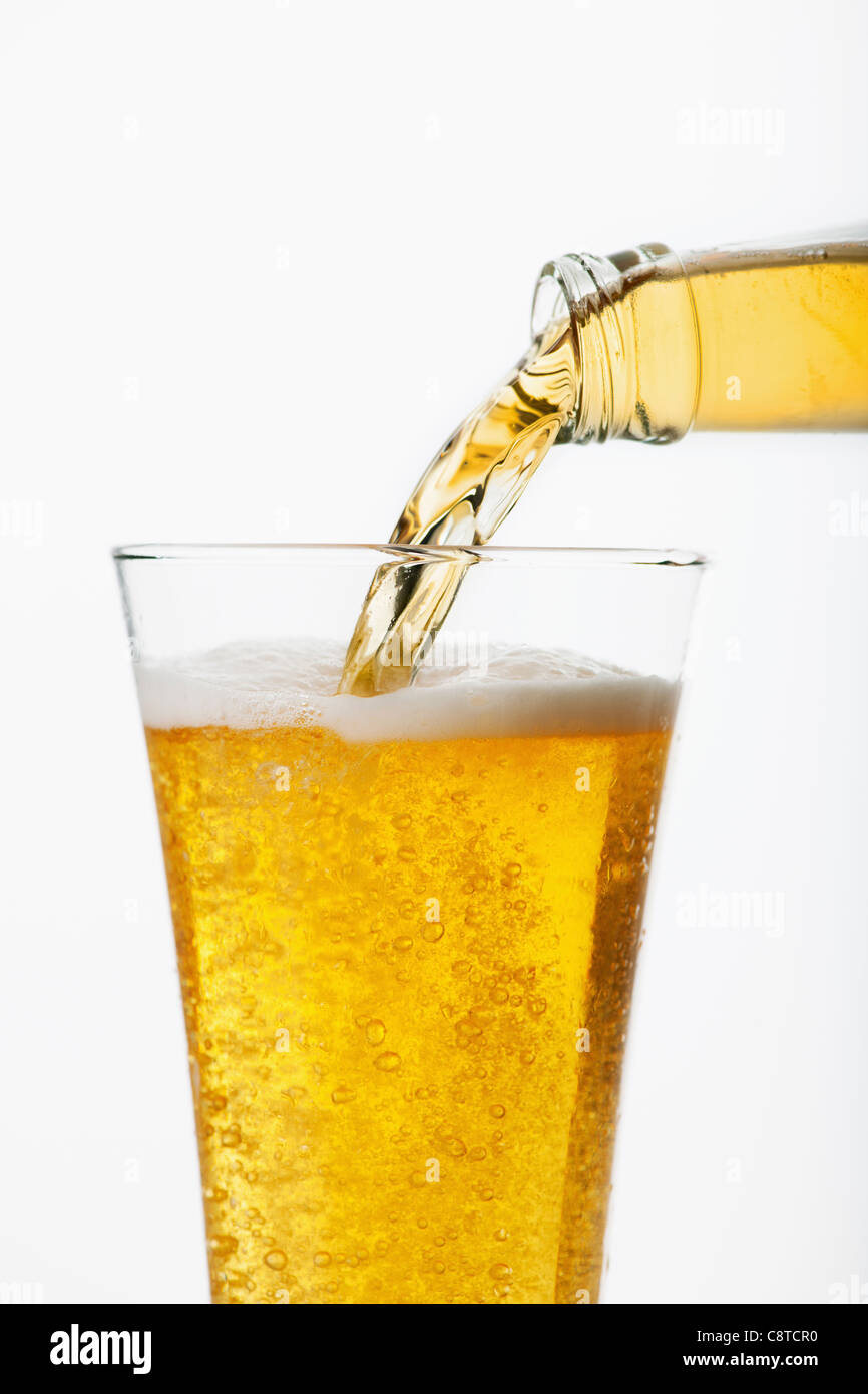 Beer pouring into glass, studio shot Stock Photo - Alamy
