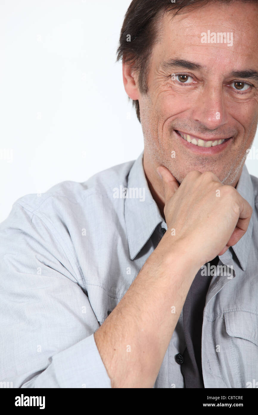 Man smiling holding chin Stock Photo - Alamy
