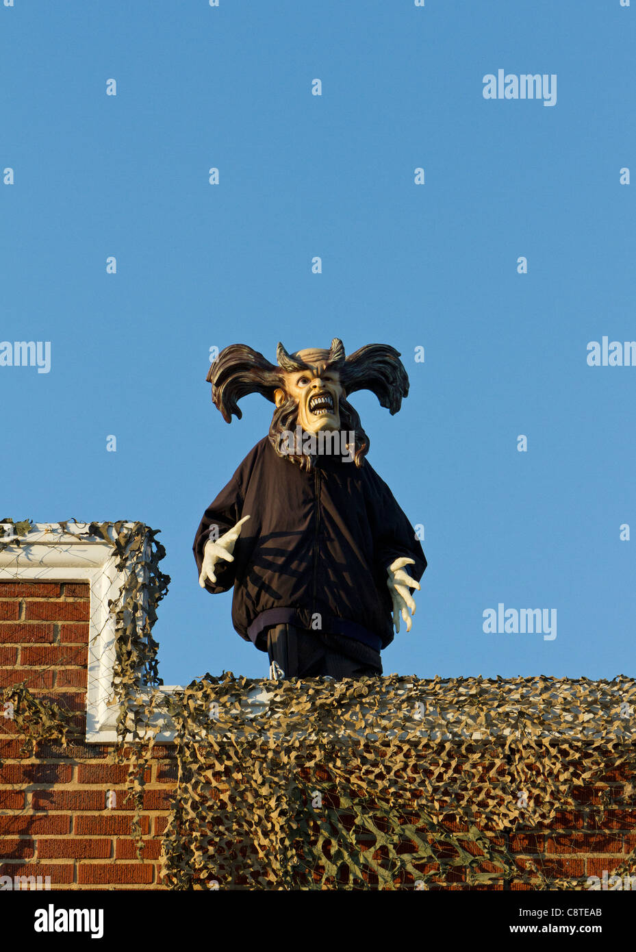 Horned demon on rooftop Stock Photo - Alamy