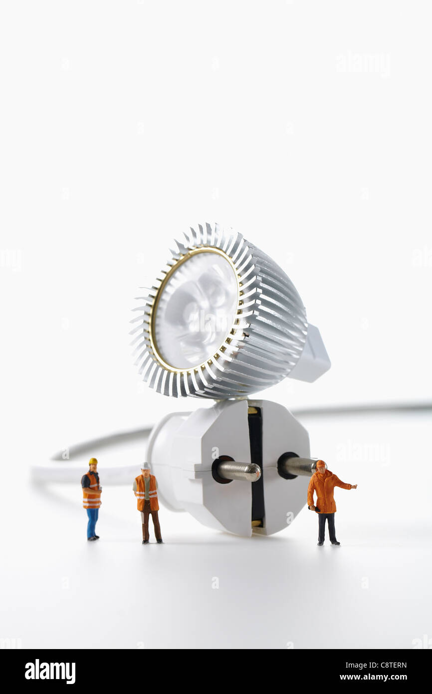 Close-up of electrical plug with small figurines Stock Photo - Alamy
