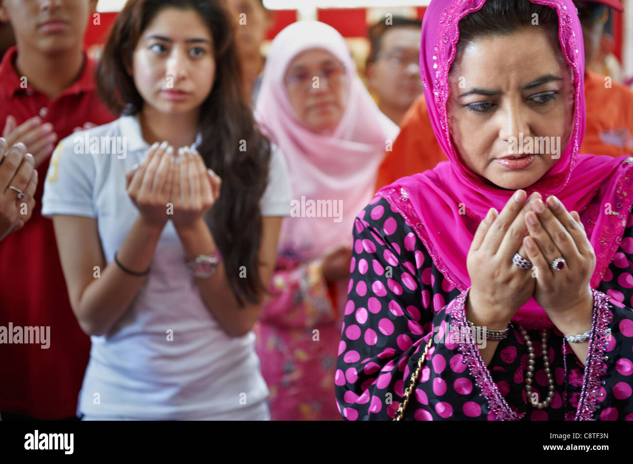 The Malaysian royal family praying together Stock Photo - Alamy