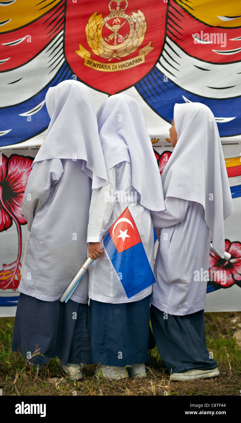 Three Malaysian students dressed in uniforms of the Army College ...