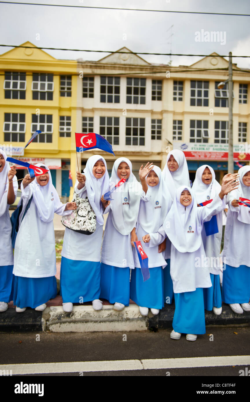 A crowd of Malaysian girls wearing uniforms happily waving flags Stock ...