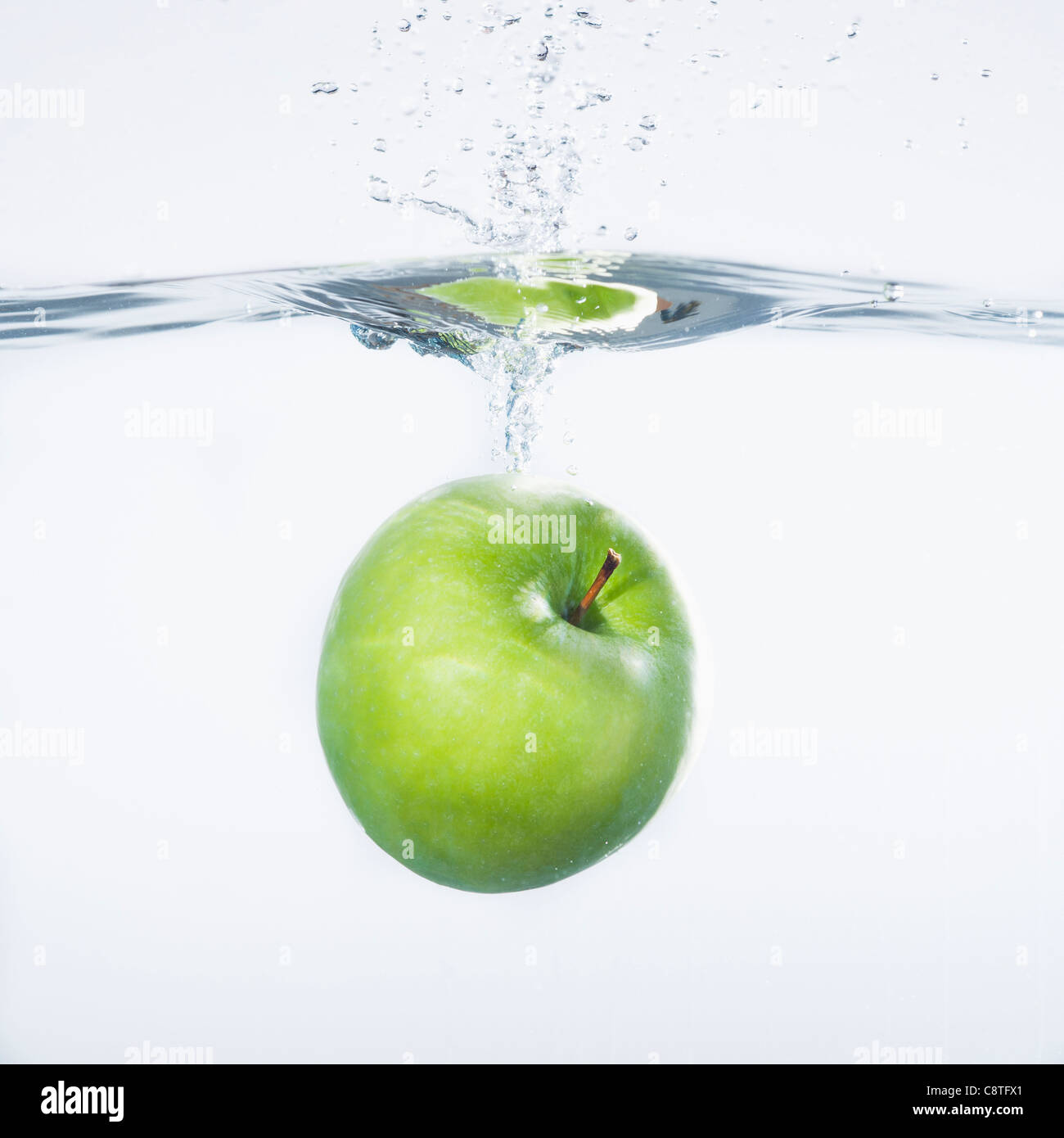 Green apple splashing into water, studio shot Stock Photo - Alamy